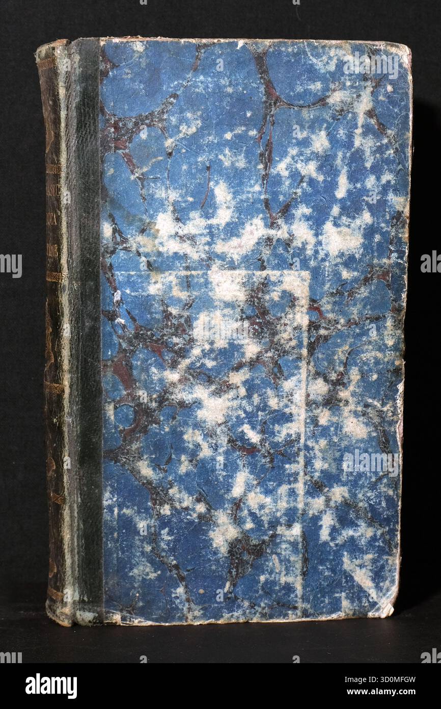 A closed antique book with a heavily worn blue, white, and burgundy ...