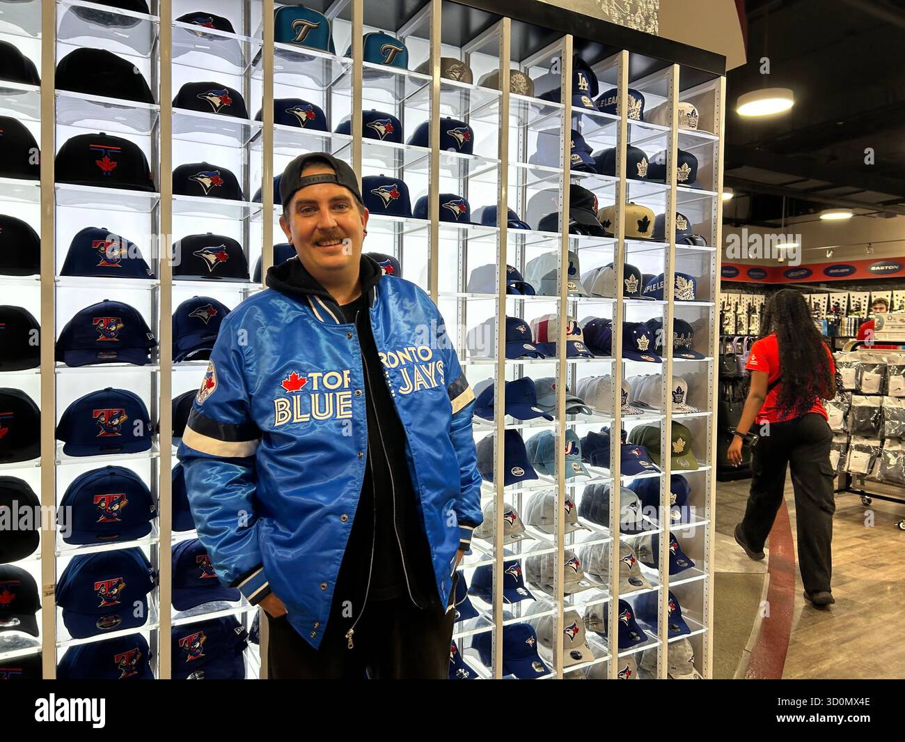 Michael Greer stands in front of a wall of Blue Jays hats at the Eaton ...