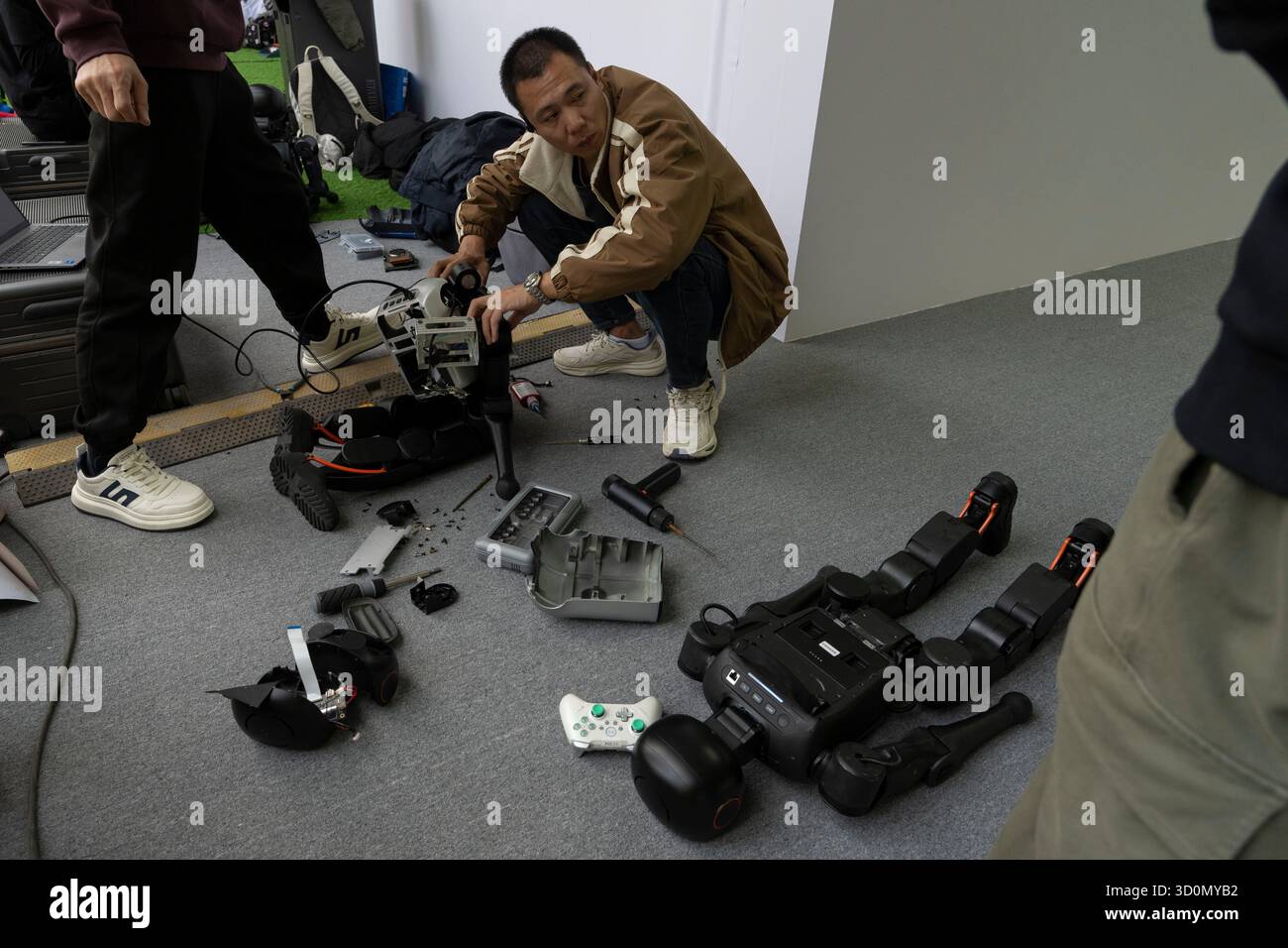 Workers repair a robot during a event by Booster Robotics in Beijing ...