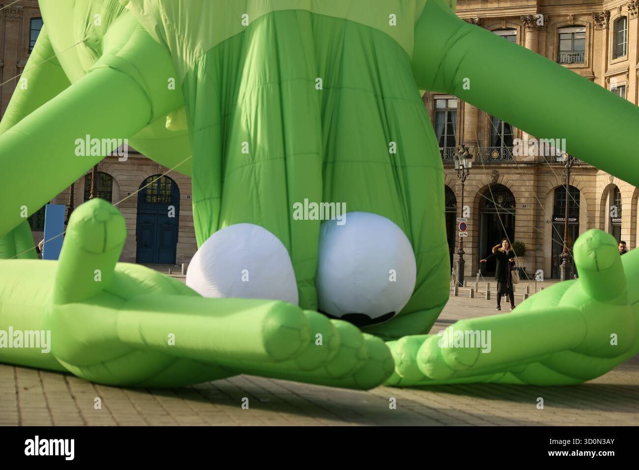 A woman pictures inflatable art piece "Kermit the Frog, Even" by ...