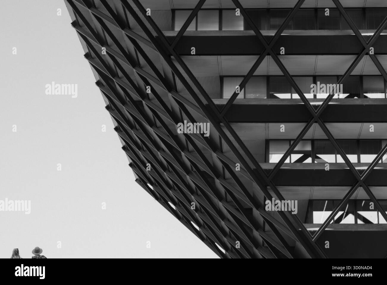 Two people, on the lower edge of the image, looking at a brutalist ...