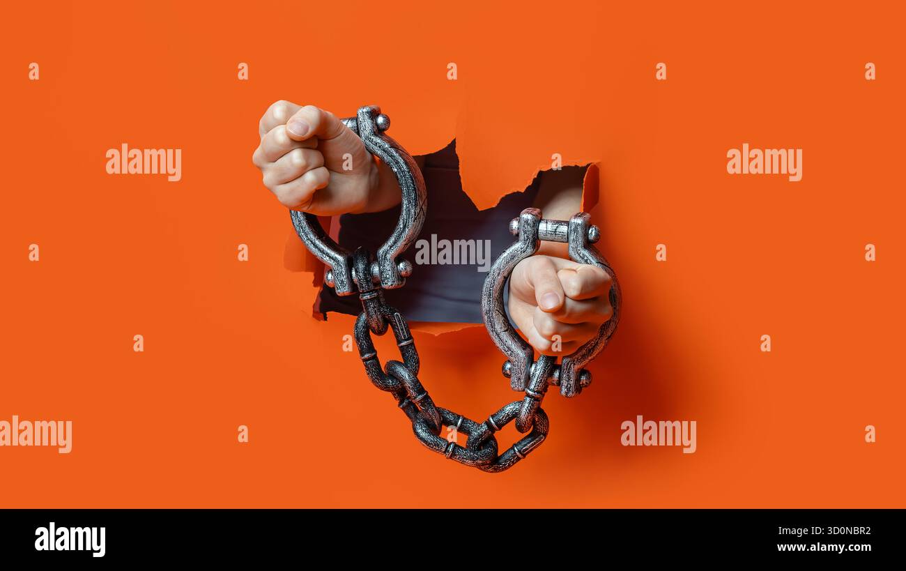 Hands in Metal Shackles. Two clenched hands in chained metal shackles ...
