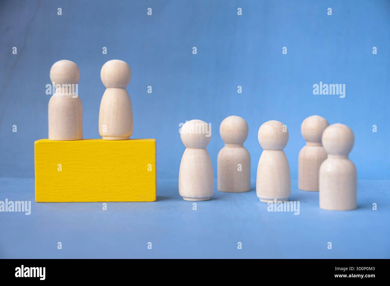 Two wooden peg figures on yellow block with blue backdrop showing unity ...