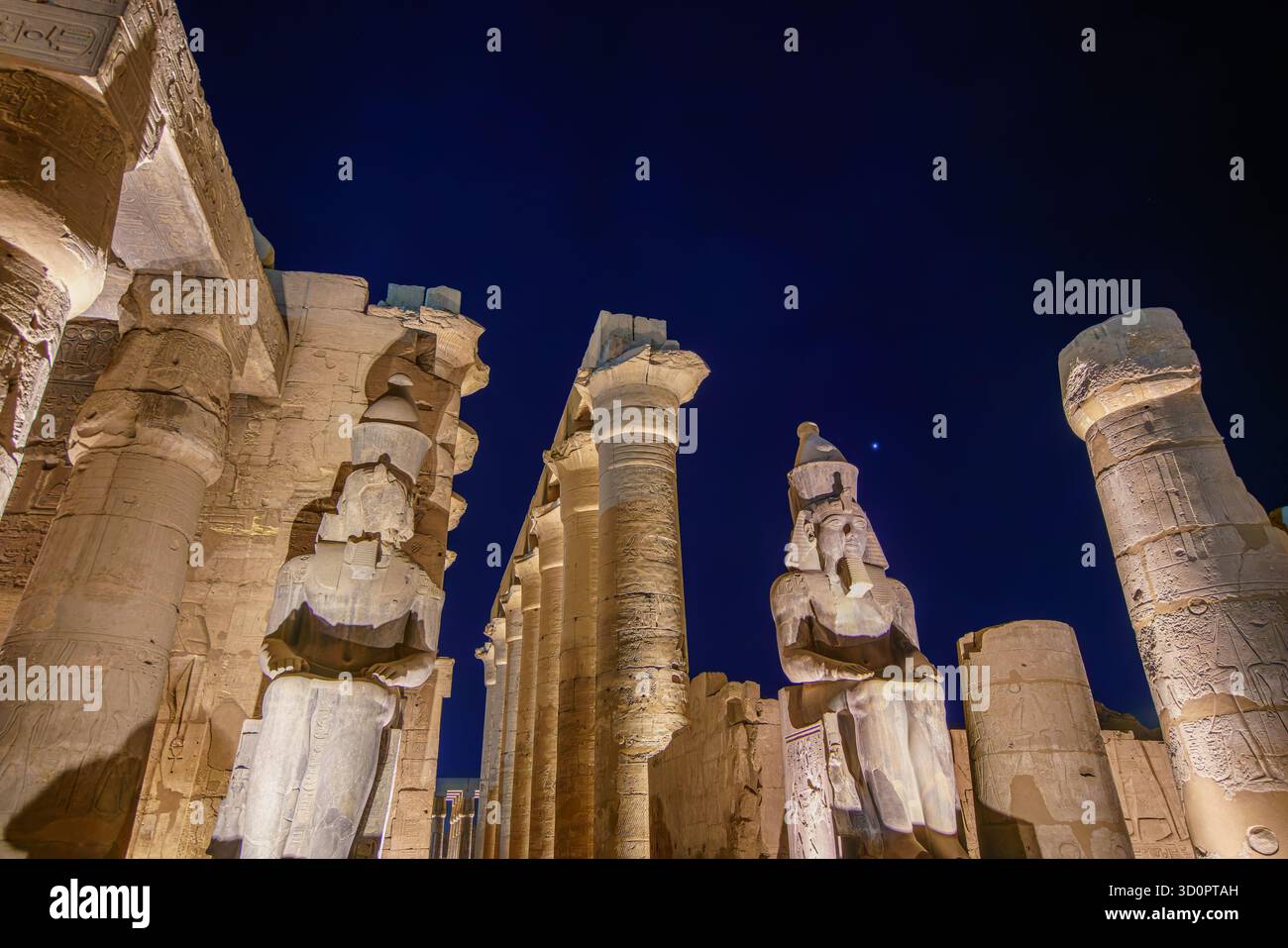 Low angle shot of the massive illuminated statues of the pharaoh Ramses ...