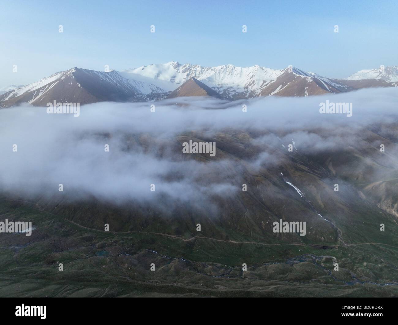 Aerial view of a flat layer of fog and clouds settled over the lower ...