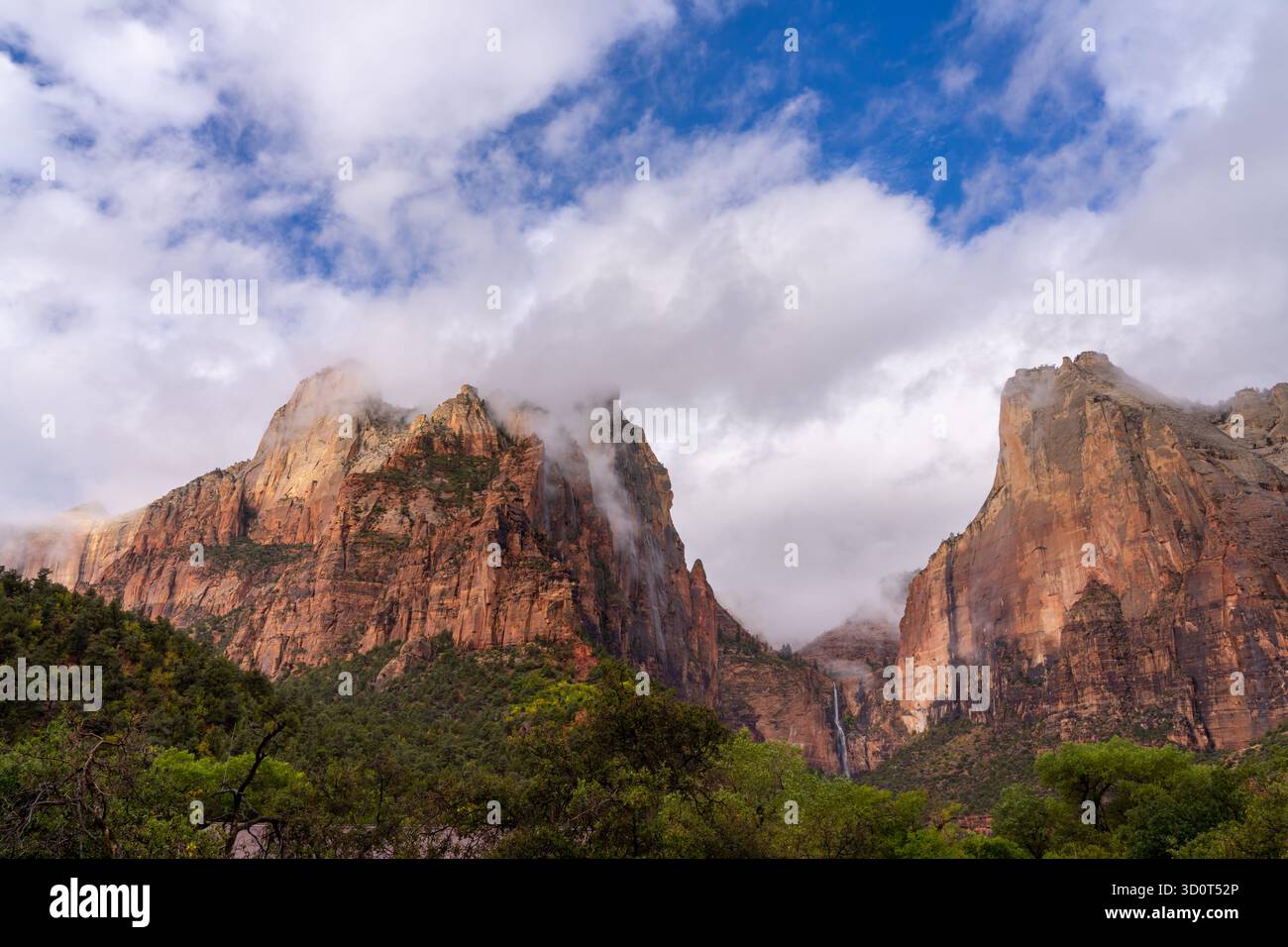 A waterfall cascades down a sheer cliff face in Zion National Park ...