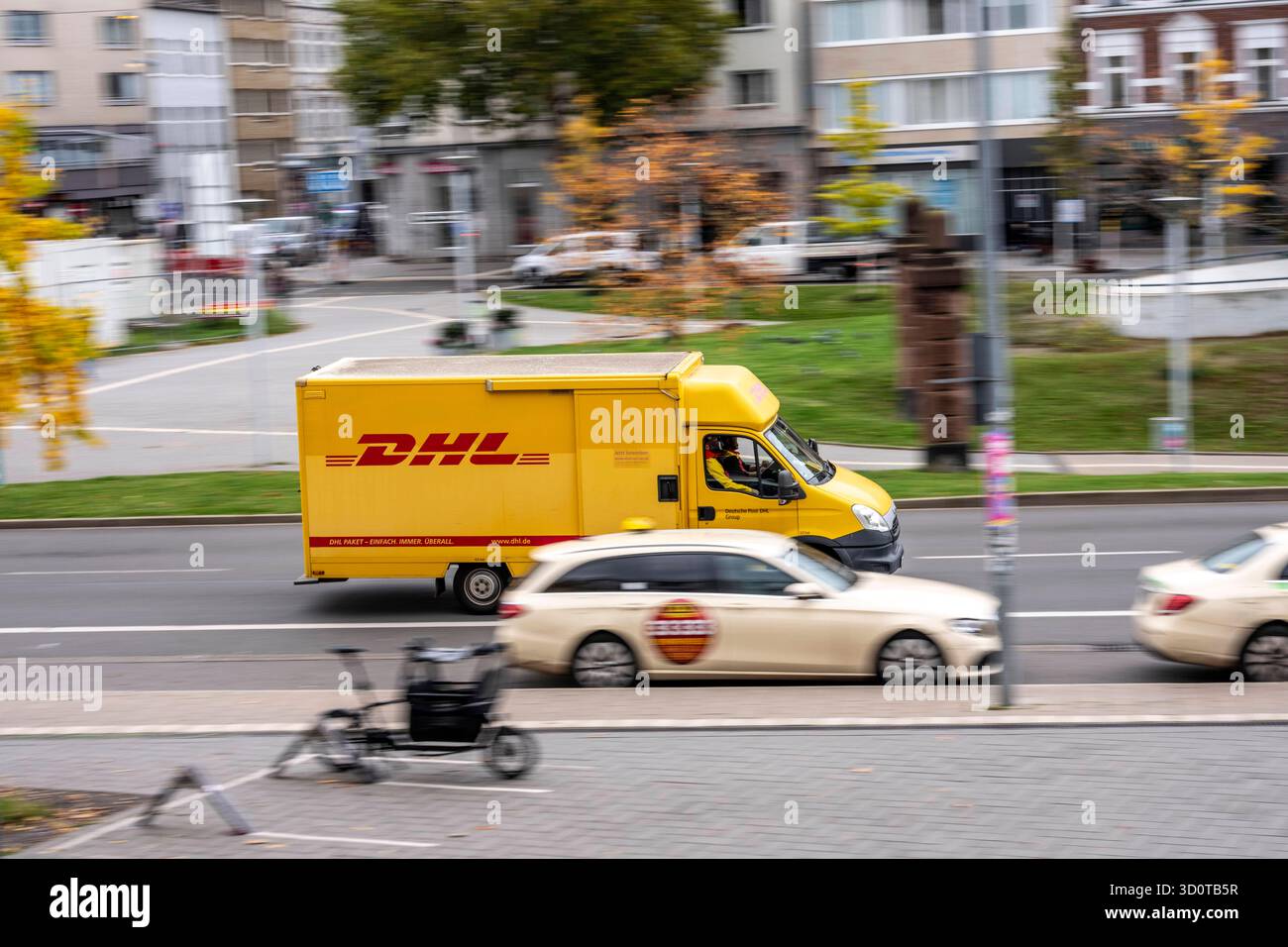 DHL Fahrzeug fährt an Taxen, am Bahnhof Düsseldorf-Bilk, vorbei ...