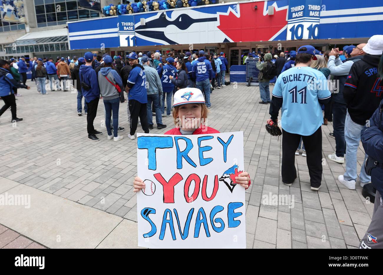 Toronto, Canada. 24th Oct, 2025. A young Blue Jays fan holds up his ...