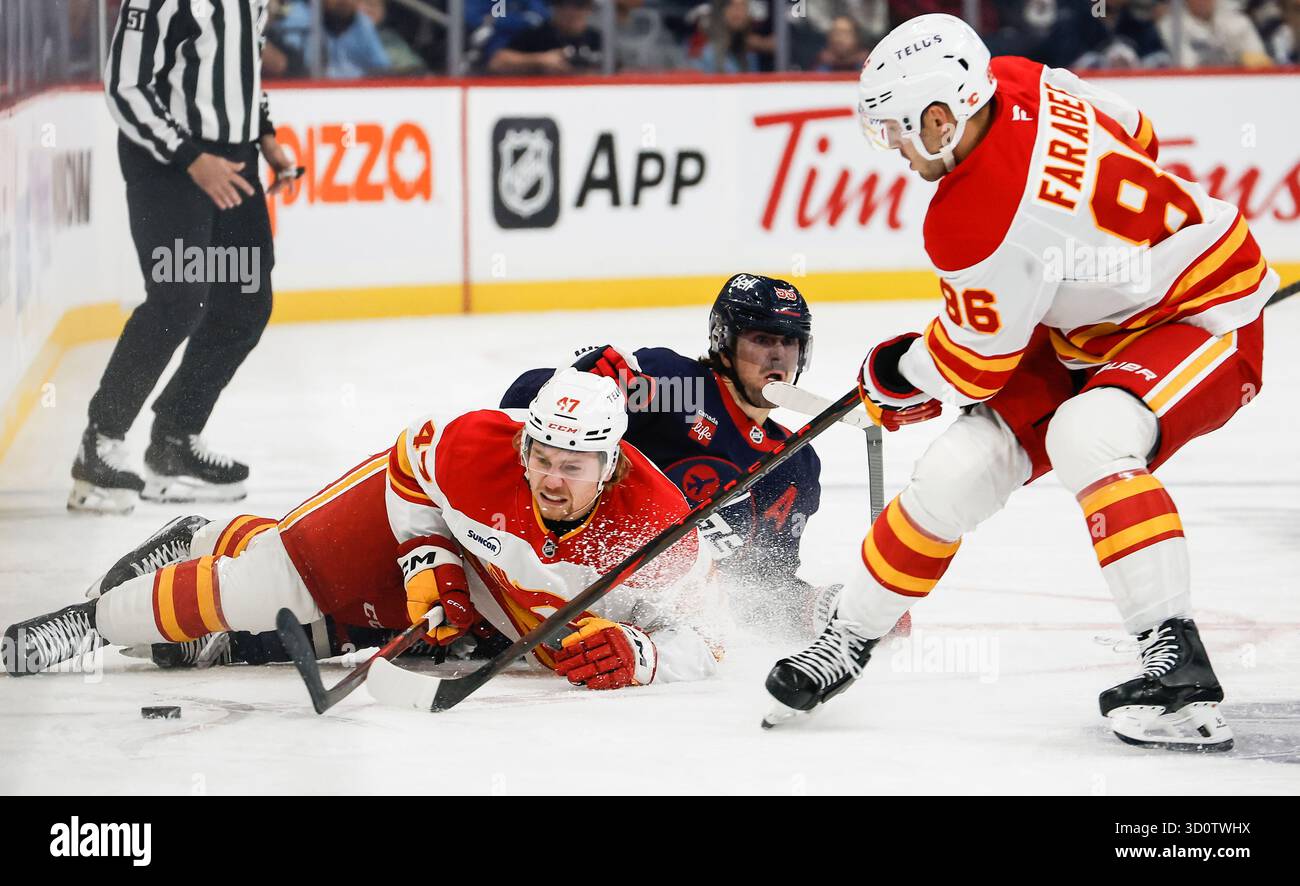 Winnipeg Jets' Mark Scheifele (centre) and Calgary Flames' Connor Zary ...
