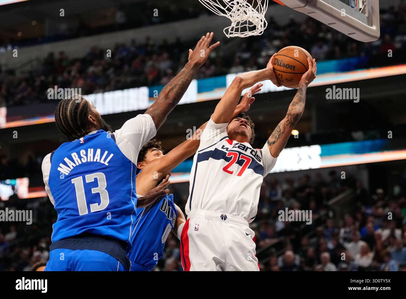 Washington Wizards guard Will Riley (27) takes a hit as he shoots over ...