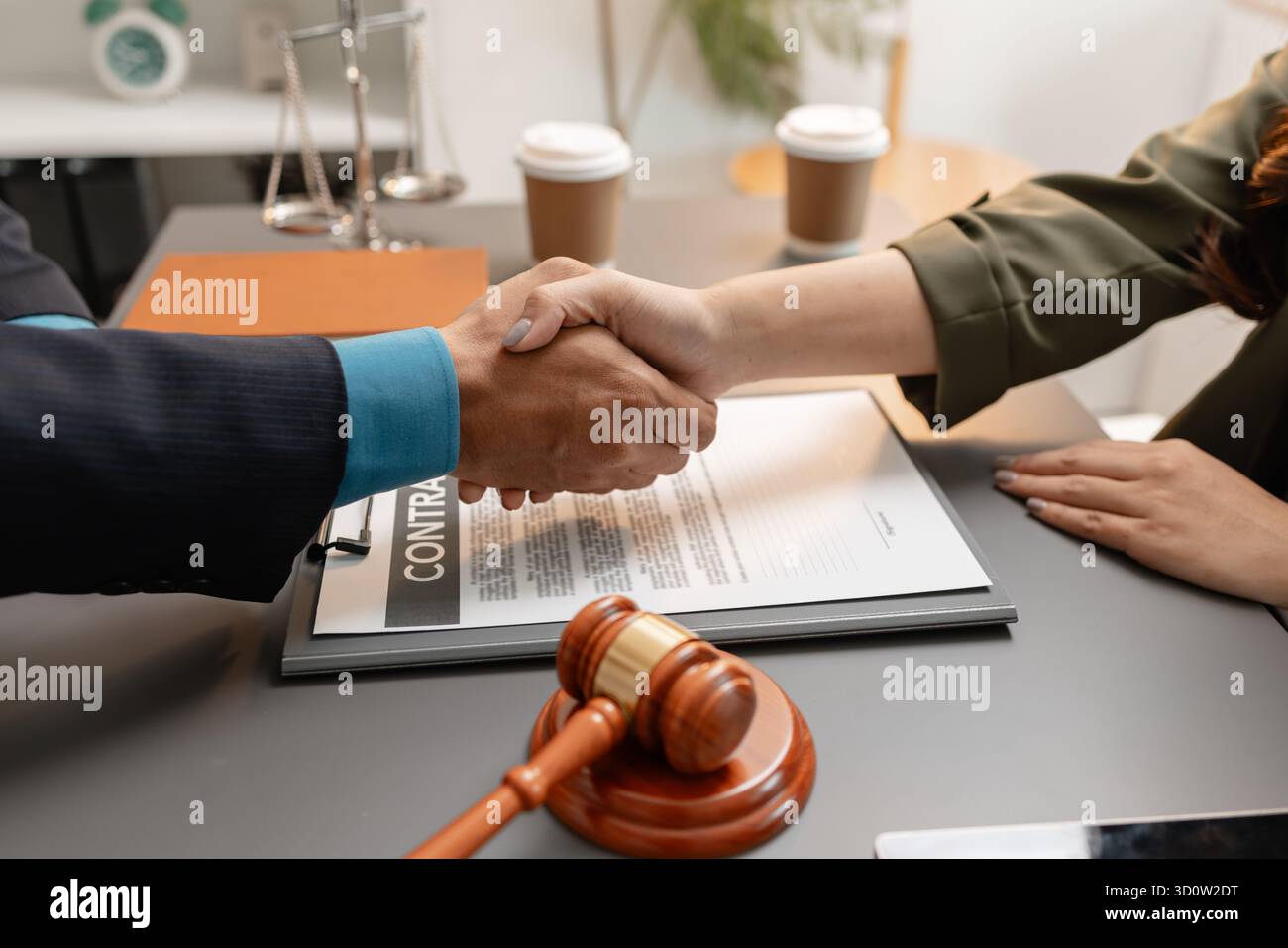A business handshake between a lawyer and client after signing a ...