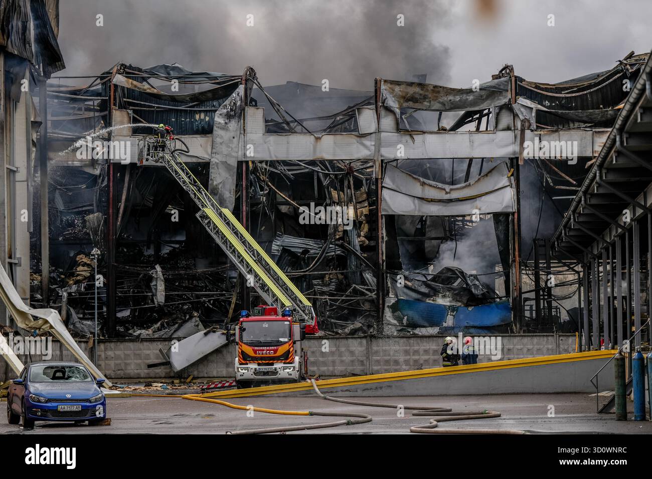 A firefighter works to extinguish a fire at a warehouse following a ...