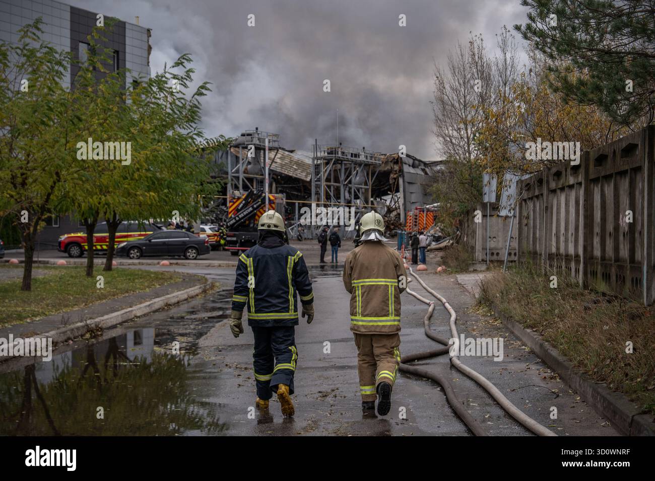Firefighters walk towards a warehouse that caught fire following a ...