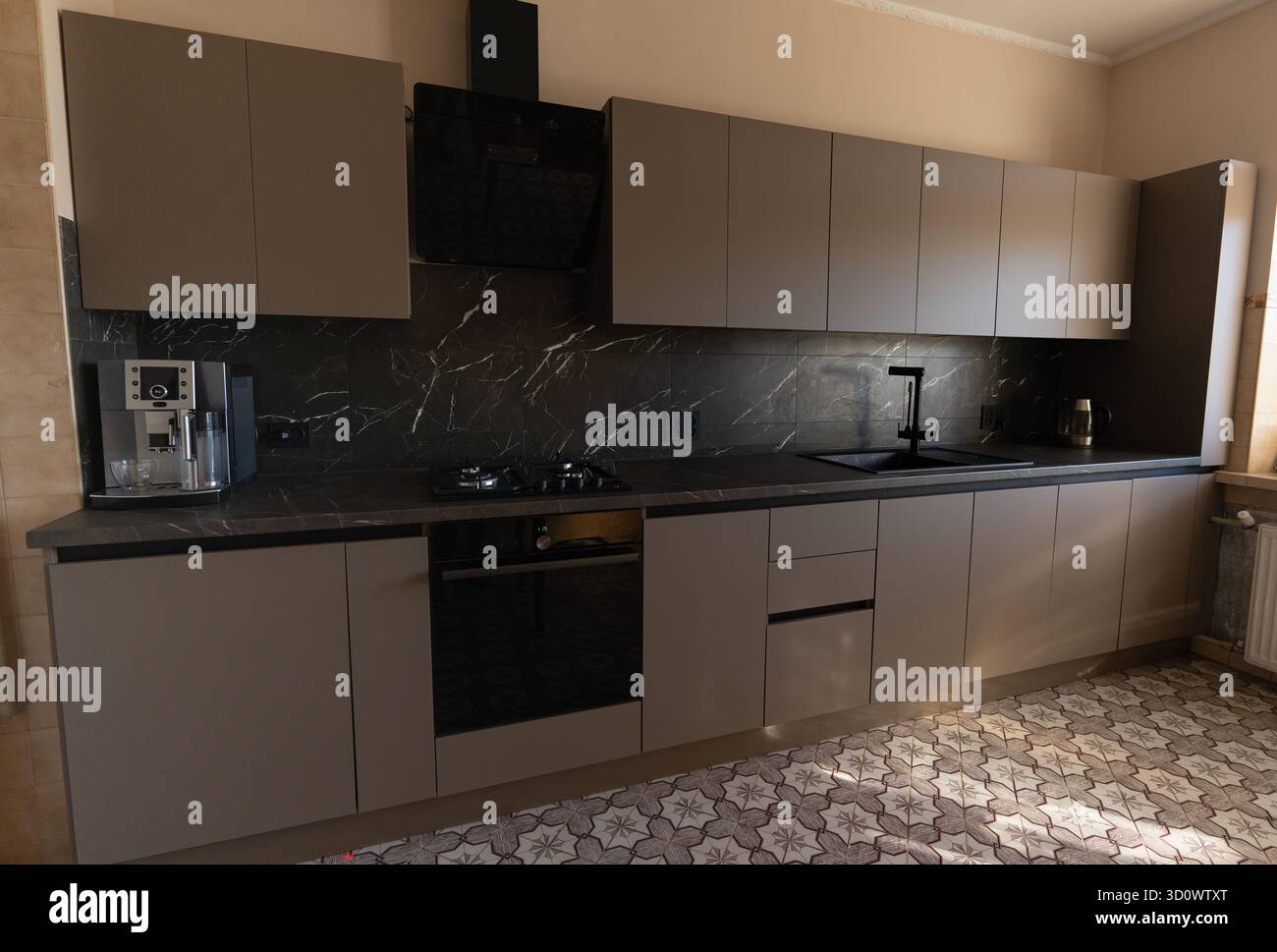 A sleek, contemporary kitchen features matte gray cabinetry, black ...
