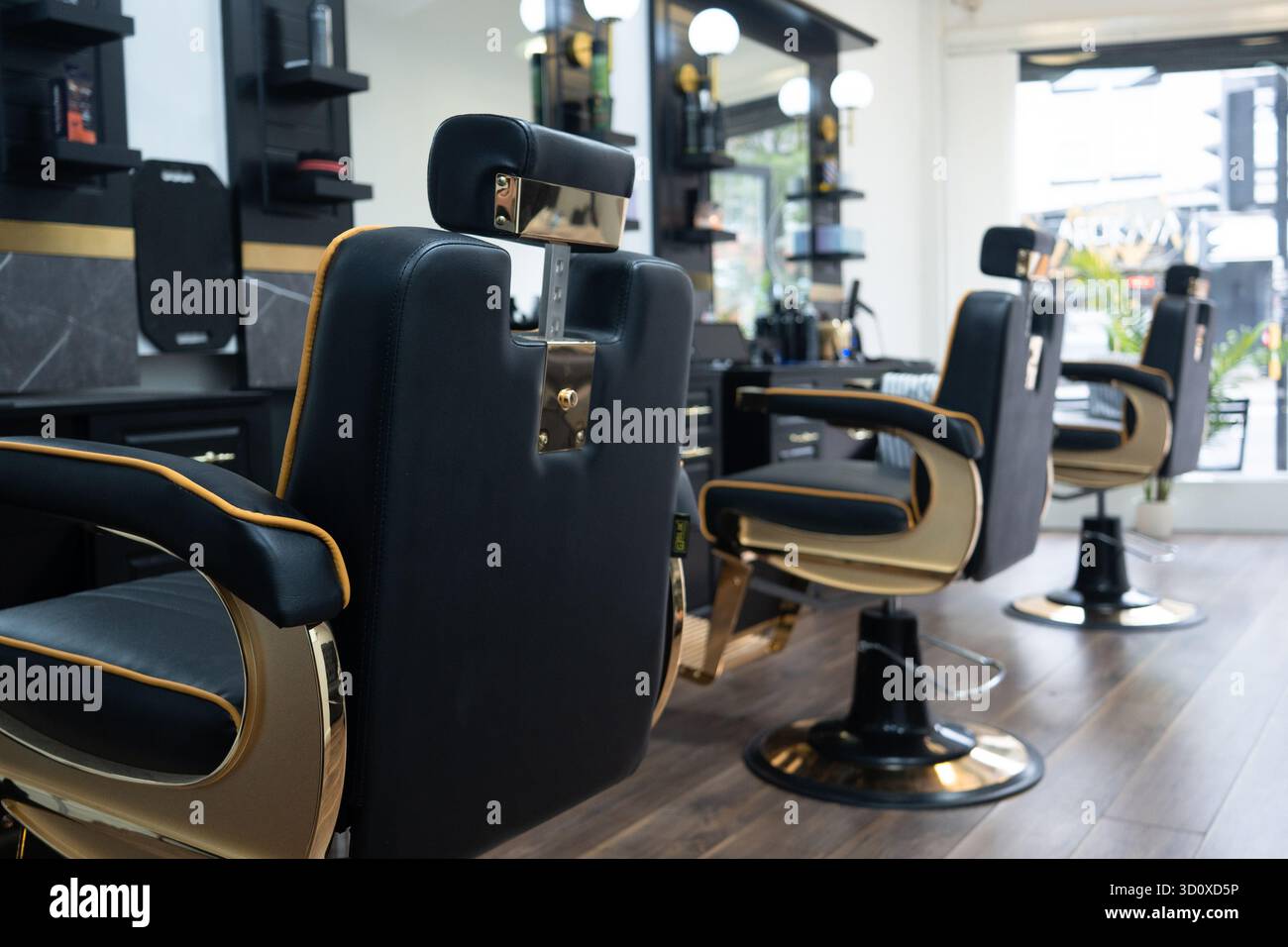 Back view of black and gold barbershop chairs with a striped barber ...