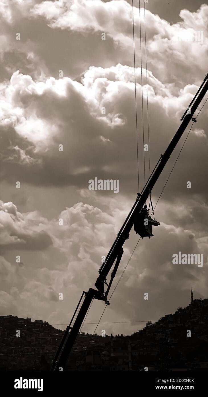 A worker stands on a crane platform A worker stands on a crane platform ...
