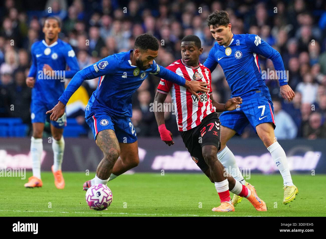 Sunderland's Noah Sadiki, center, tries to dribble the ball past ...