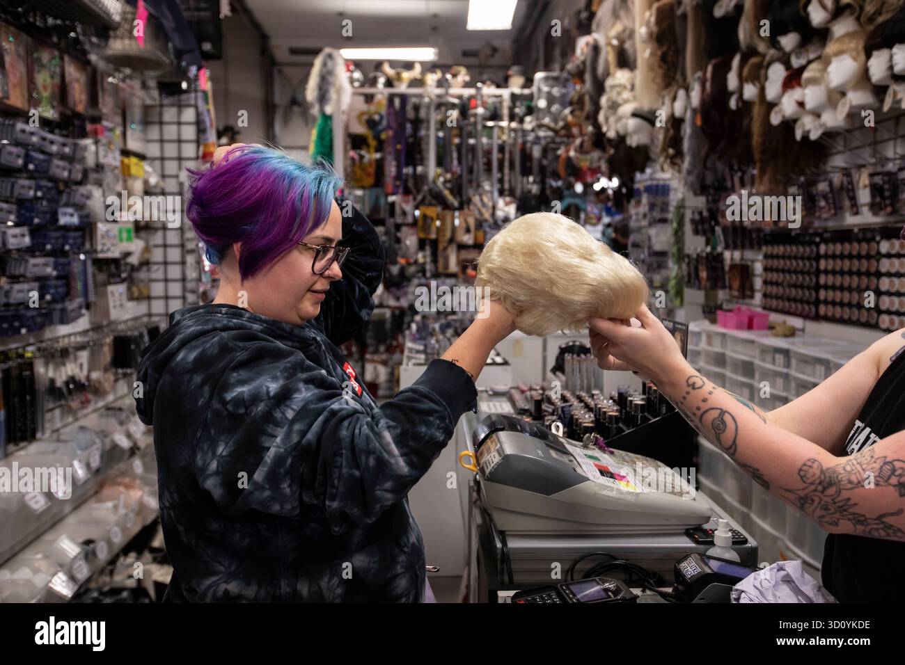Stephanie LaBute tries on a Donald Trump style of wig, wth the help of ...