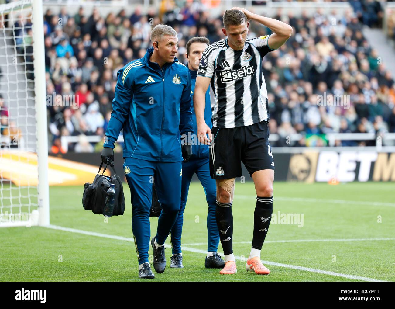 Newcastle United's Sven Botman walks off the field with the medical ...