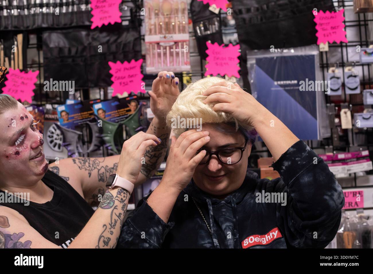 Stephanie LaBute tries on a Donald Trump style of wig, wth the help of ...