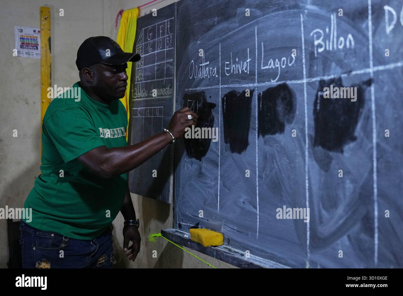 An election official records poll result on a chalkboard at a polling ...