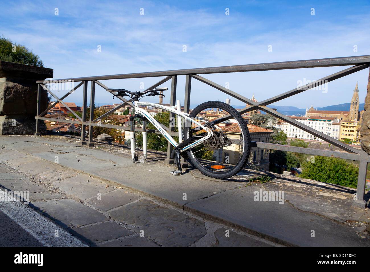 Bicycle missing parts locked to railing with panoramic view of Florence ...
