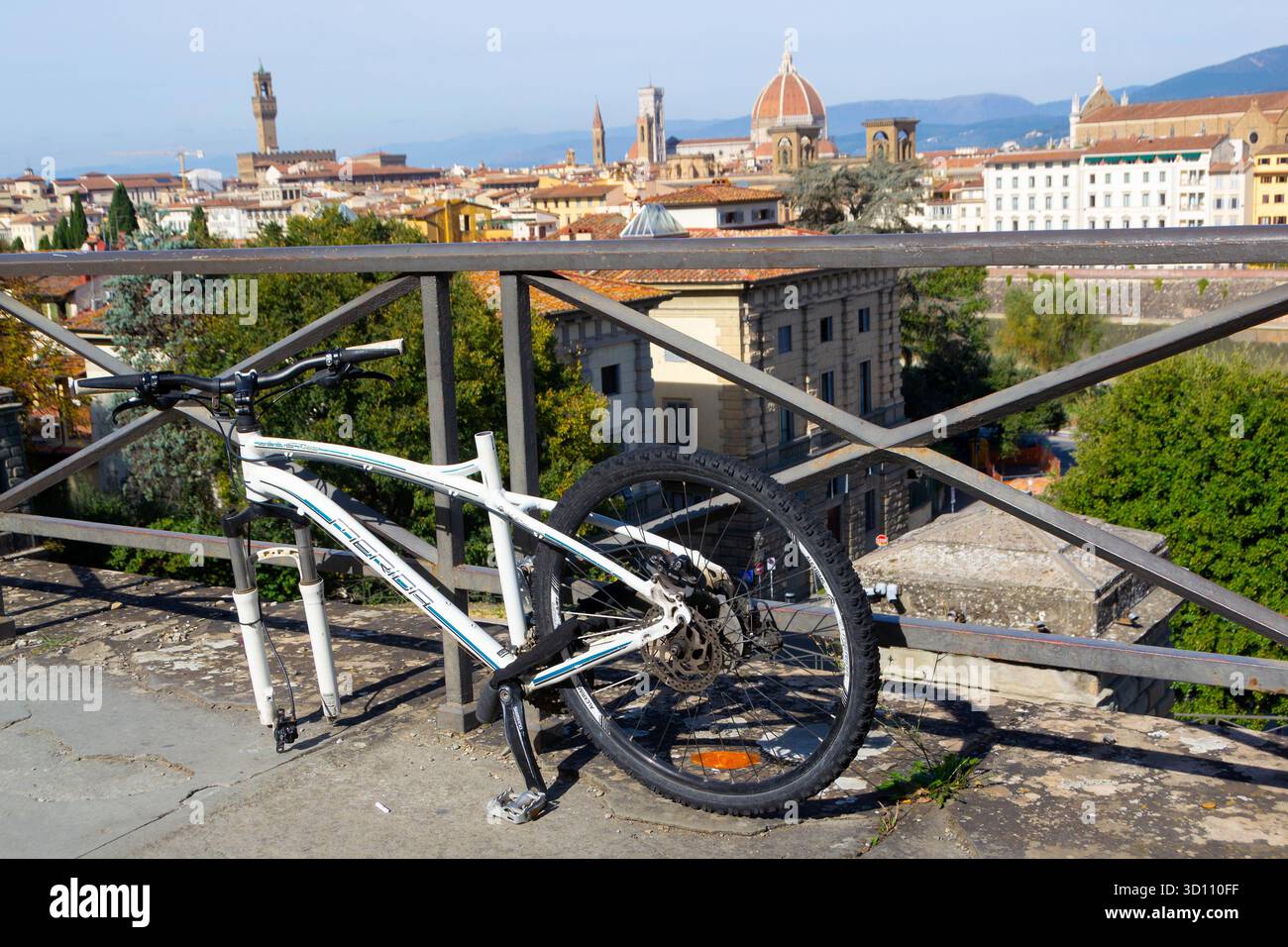 Bicycle missing parts locked to railing with panoramic view of Florence ...