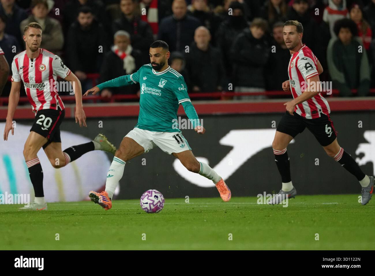 Liverpool's Mohamed Salah in action between Brentford's Aaron Hickey ...
