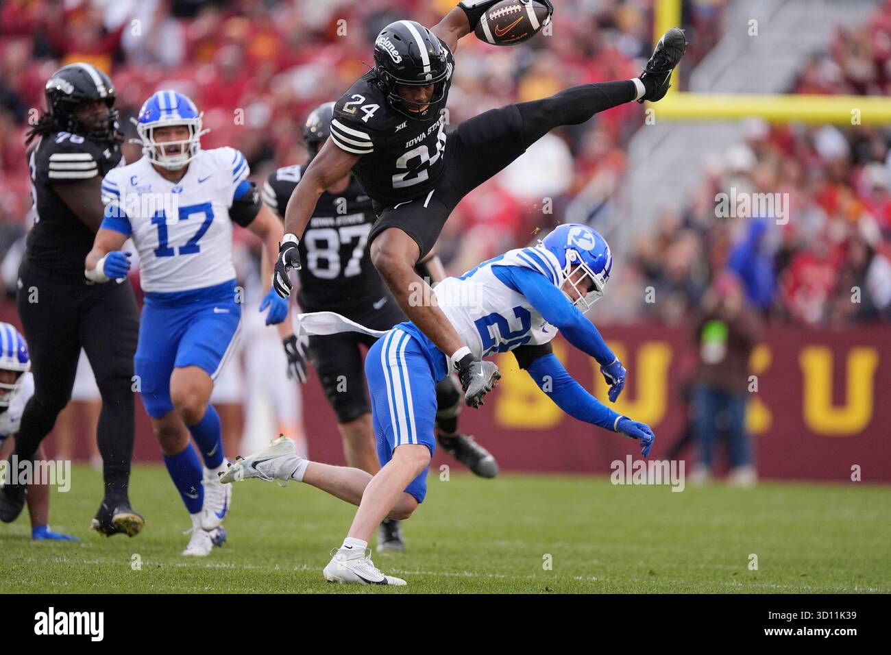 Iowa State running back Abu Sama (24) leaps over BYU safety Tanner Wall ...