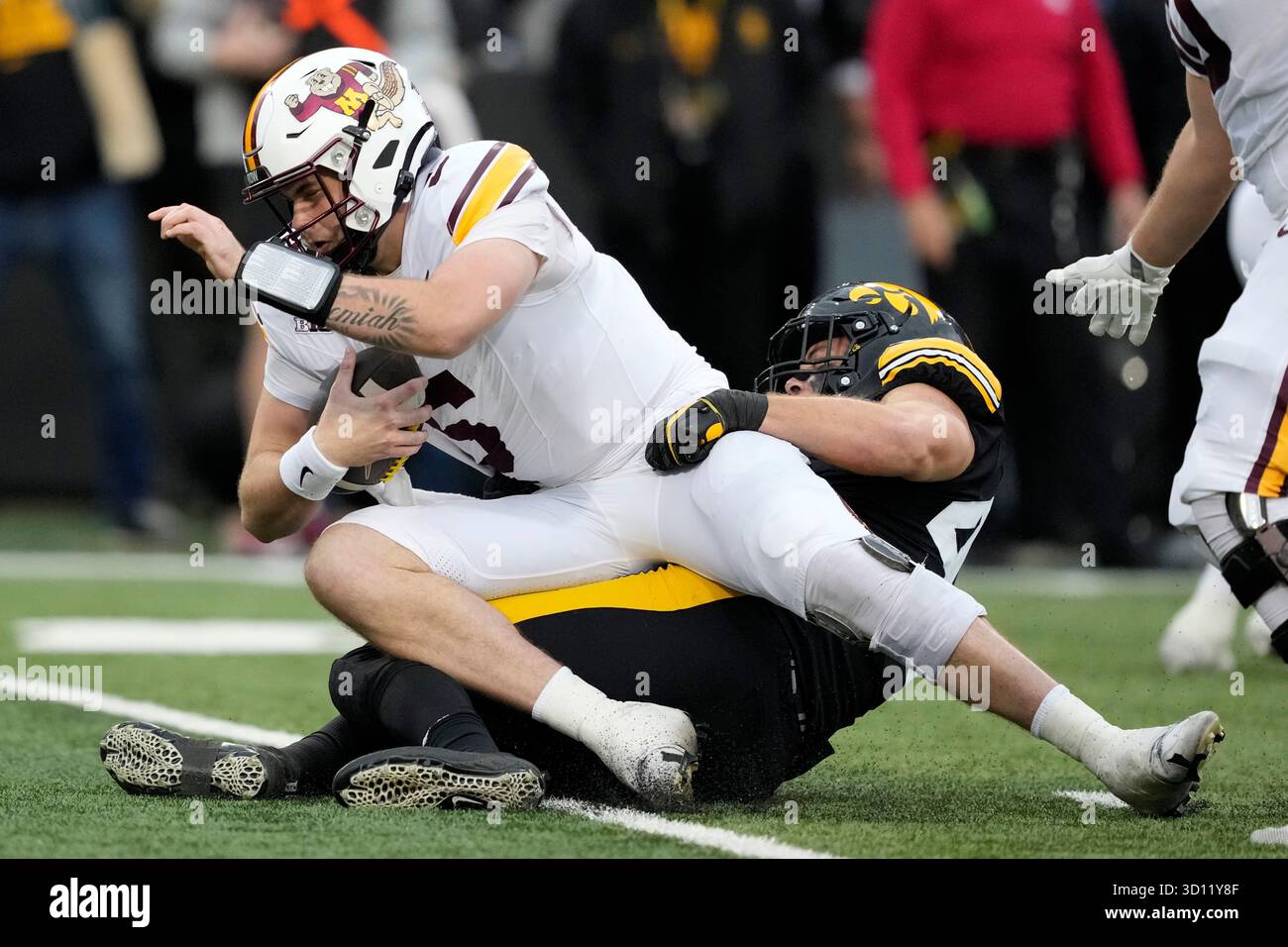 Minnesota quarterback Drake Lindsey (5) is sacked by Iowa defensive ...