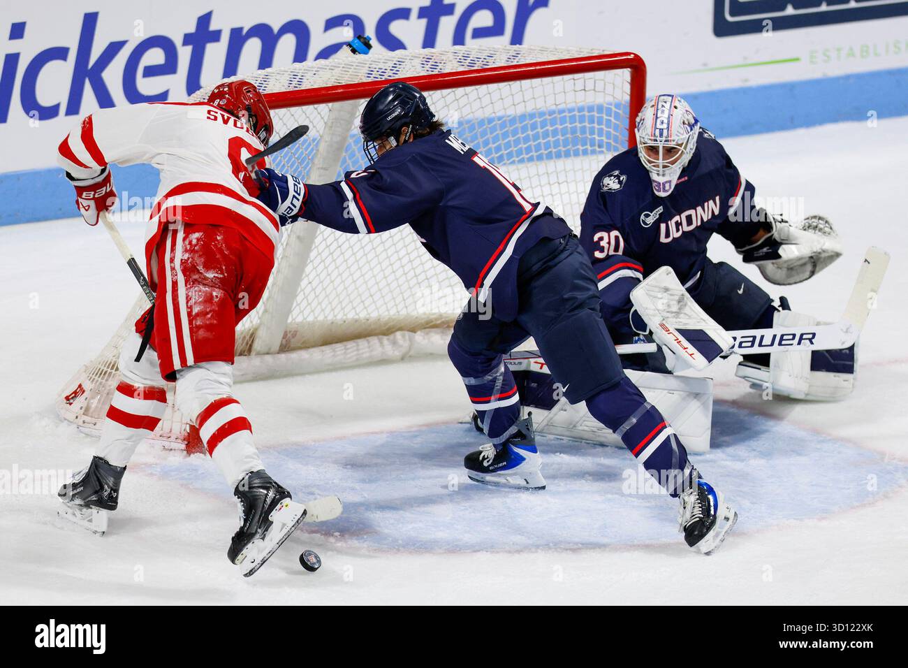 UConn defenseman Thomas Messineo (15) pushes Boston University forward ...