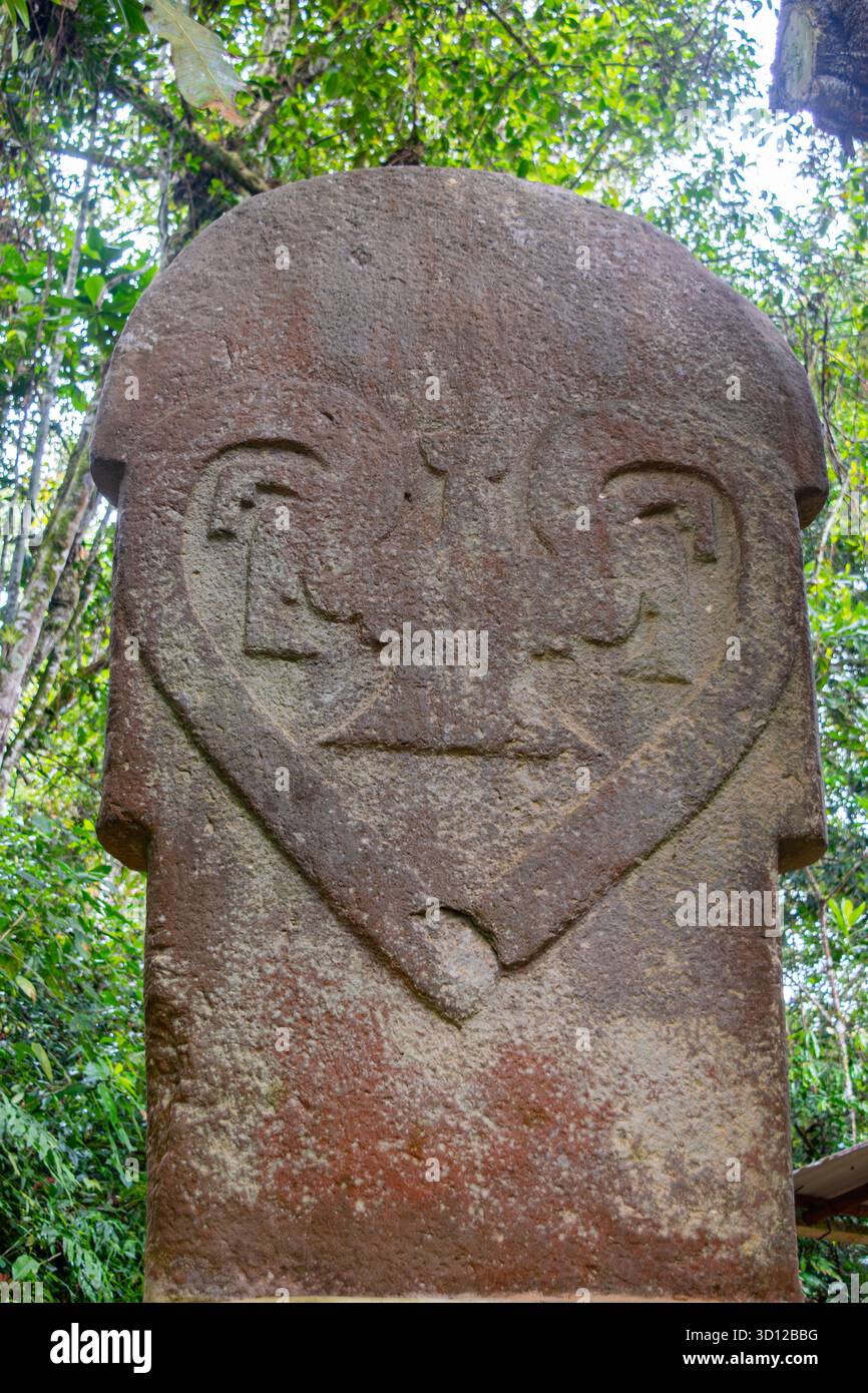 An ancient stone statue with intricate carvings, nestled within lush ...