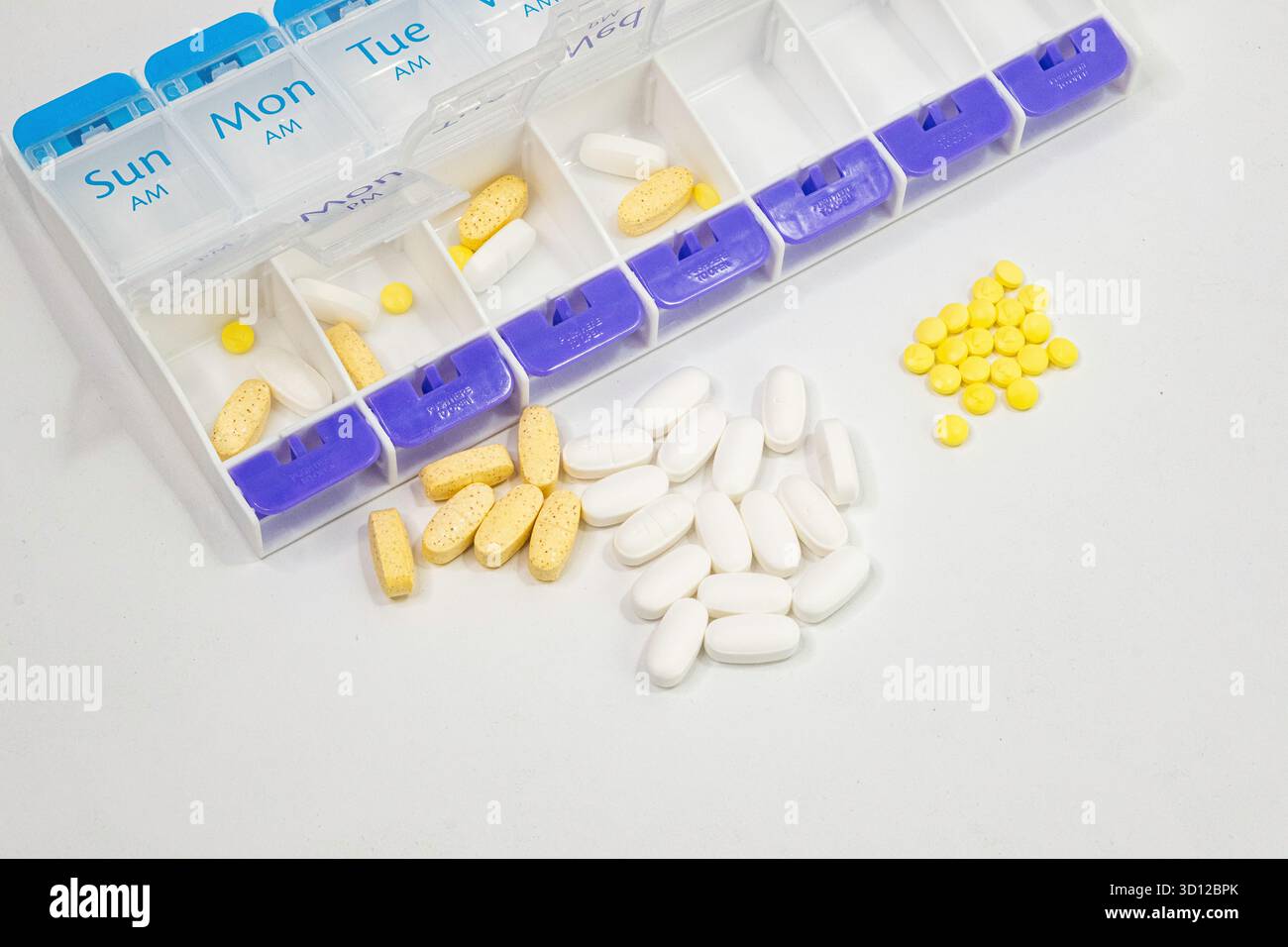 An overhead close up view showing a partially filled pill box with ...