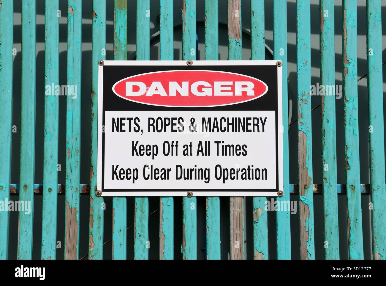 Danger sign warning to keep off of nets, ropes and machinery mounted on ...