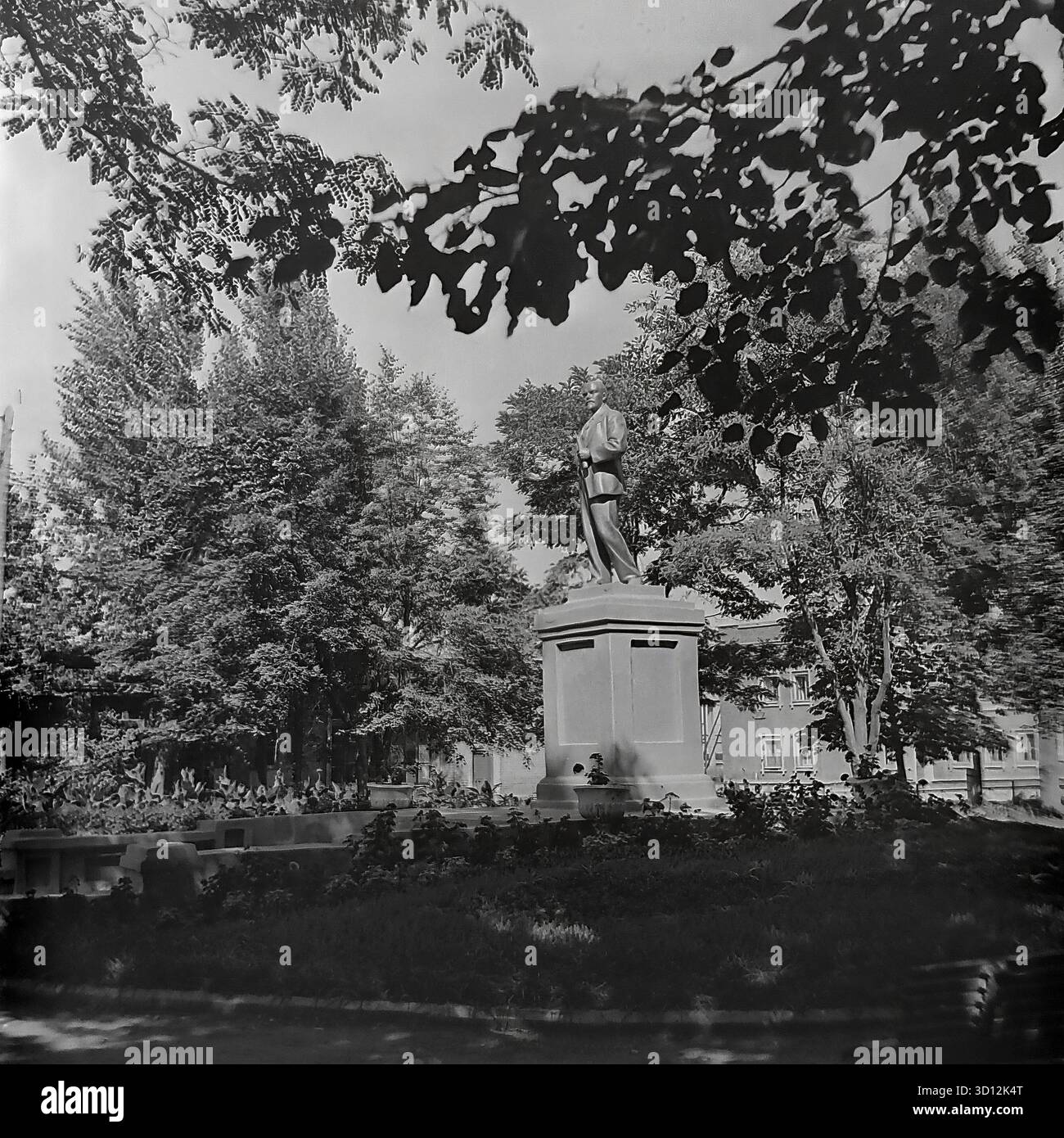 A monument to Vladimir Lenin stands in a green park or square in the ...