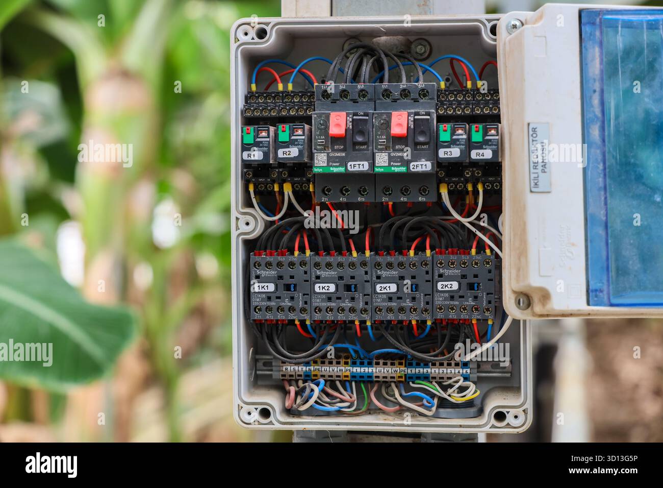 Open electrical control box with colorful wires and switches inside a ...