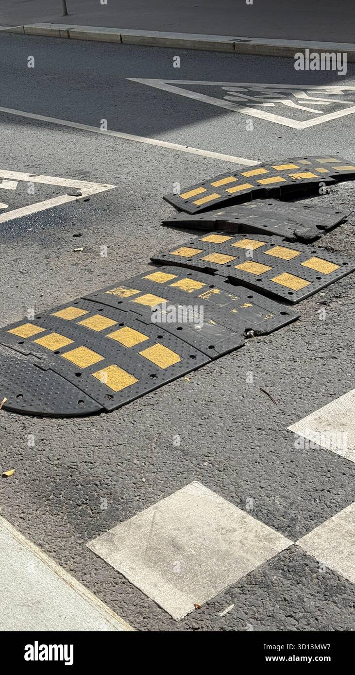 Damaged speed bump on asphalt road with yellow markings for traffic ...