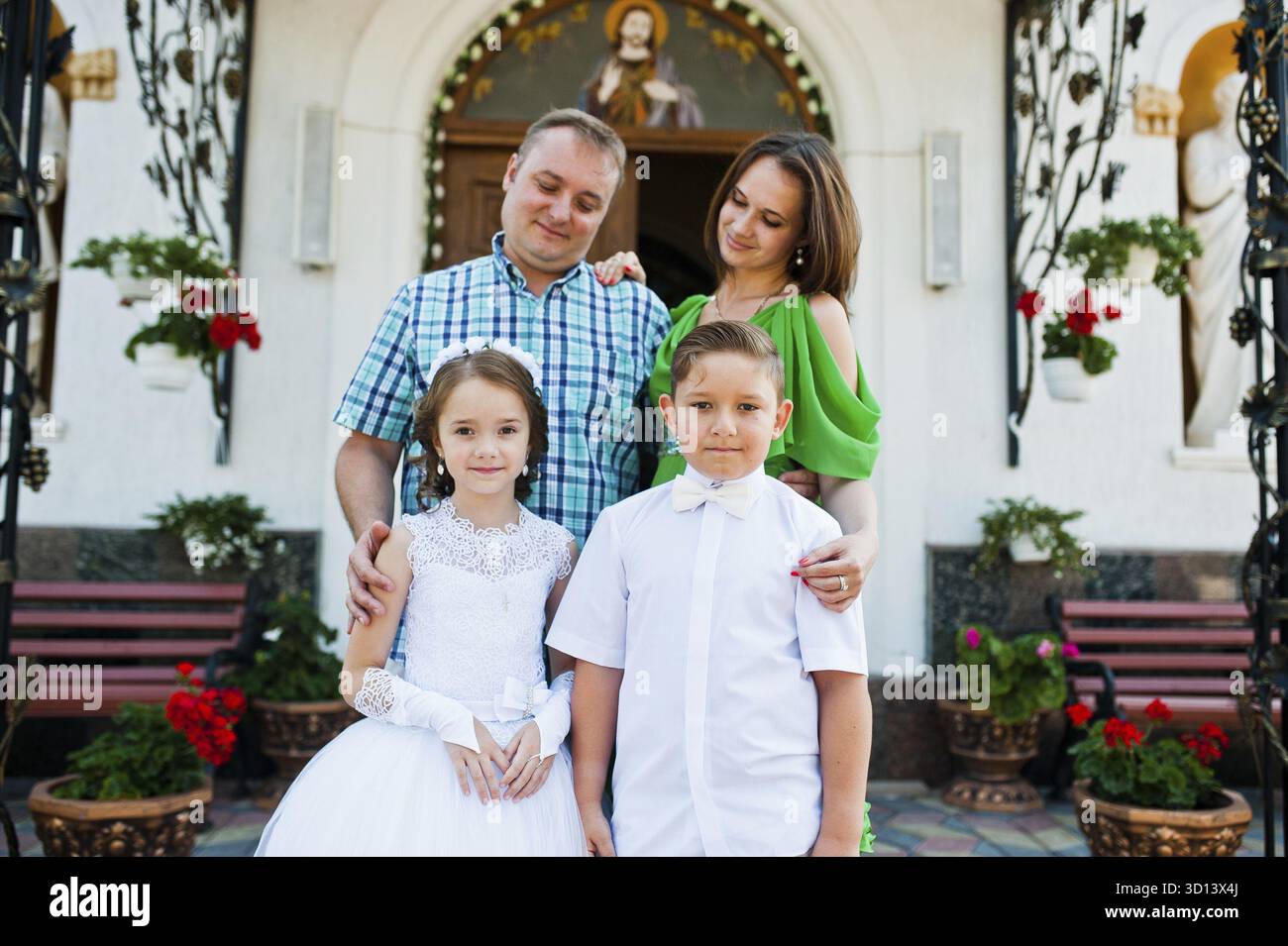 Happy family at first holy communion stay background church Stock Photo ...