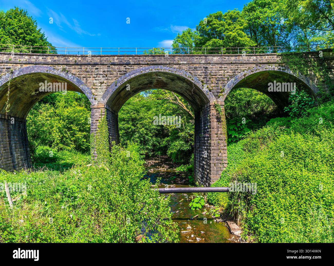 A view towards a three arched a bridge across the River Goyt at New ...