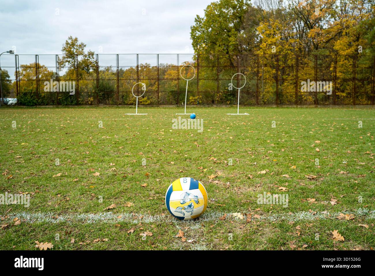 The volleyball is seen in front of the three Quadball hoops. On the ...