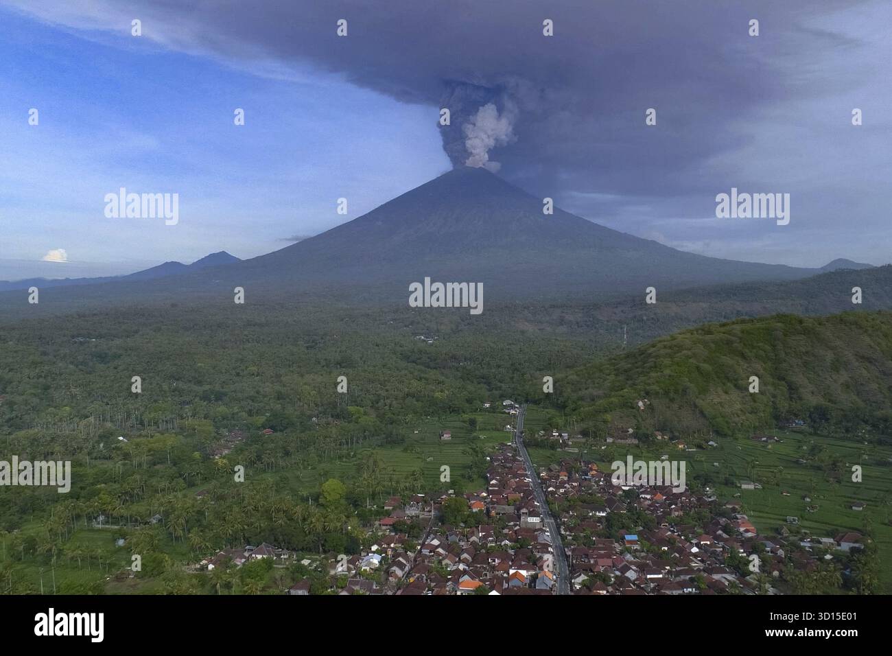 Ashes rising from the volcano. The village at the foot of the volcano ...