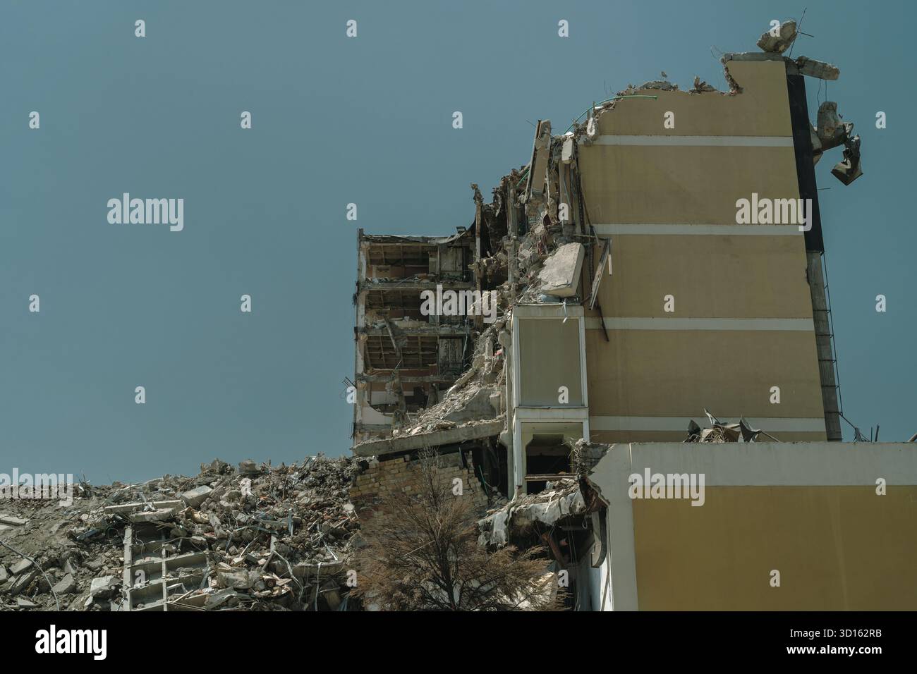 Severely damaged multi-story building surrounded by debris, because of ...