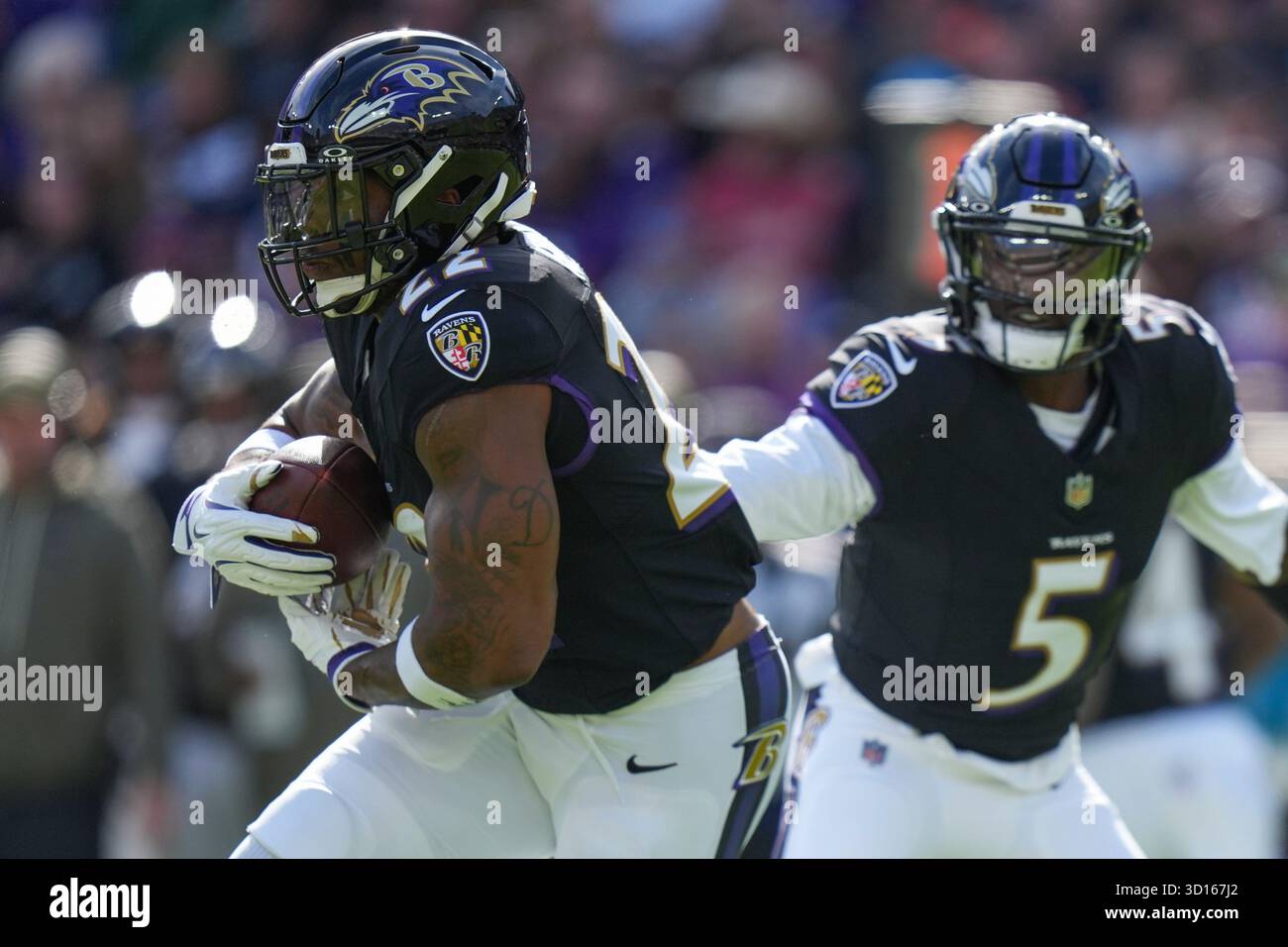 Baltimore Ravens quarterback Tyler Huntley (5), right, hands the ball ...