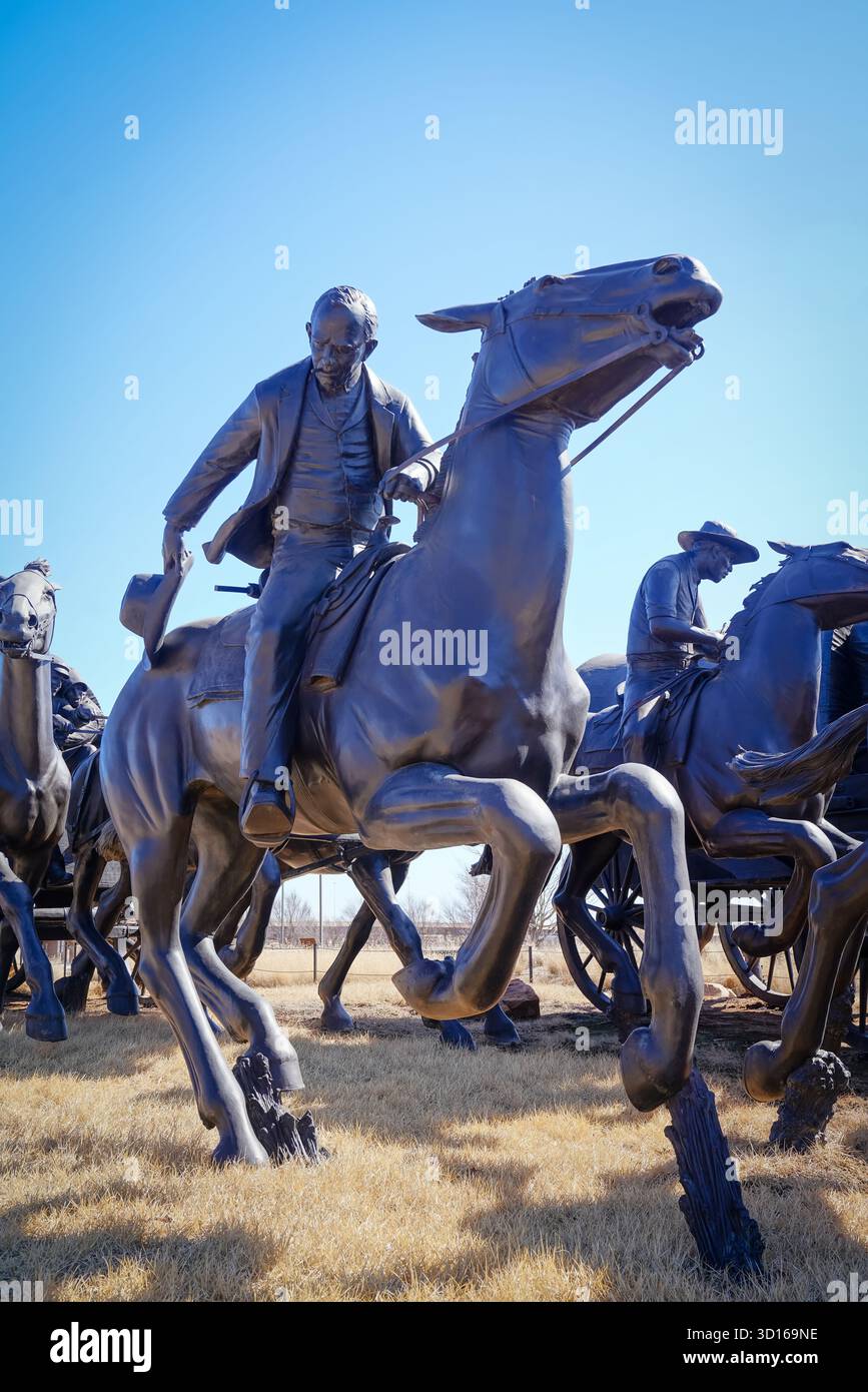 Bronze horses and riders race beside a covered wagon at the Centennial ...