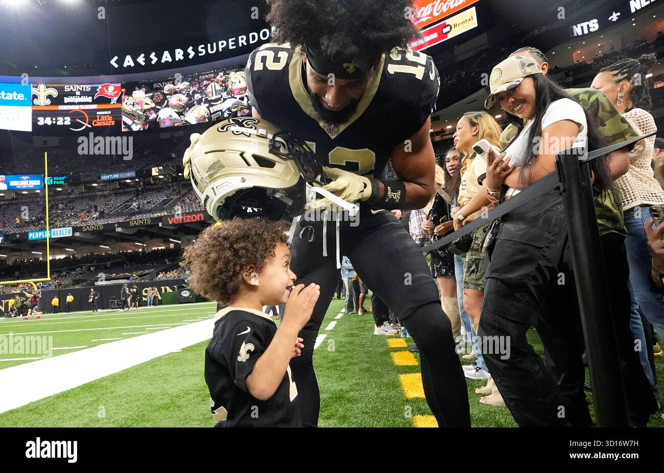 New Orleans Saints wide receiver Chris Olave (12) puts his helmet on ...