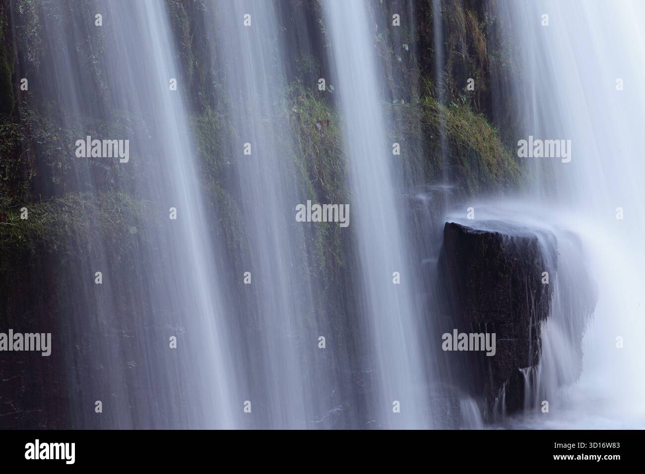 A simple, intimate, zoomed image of a waterfall cascade hitting a large ...
