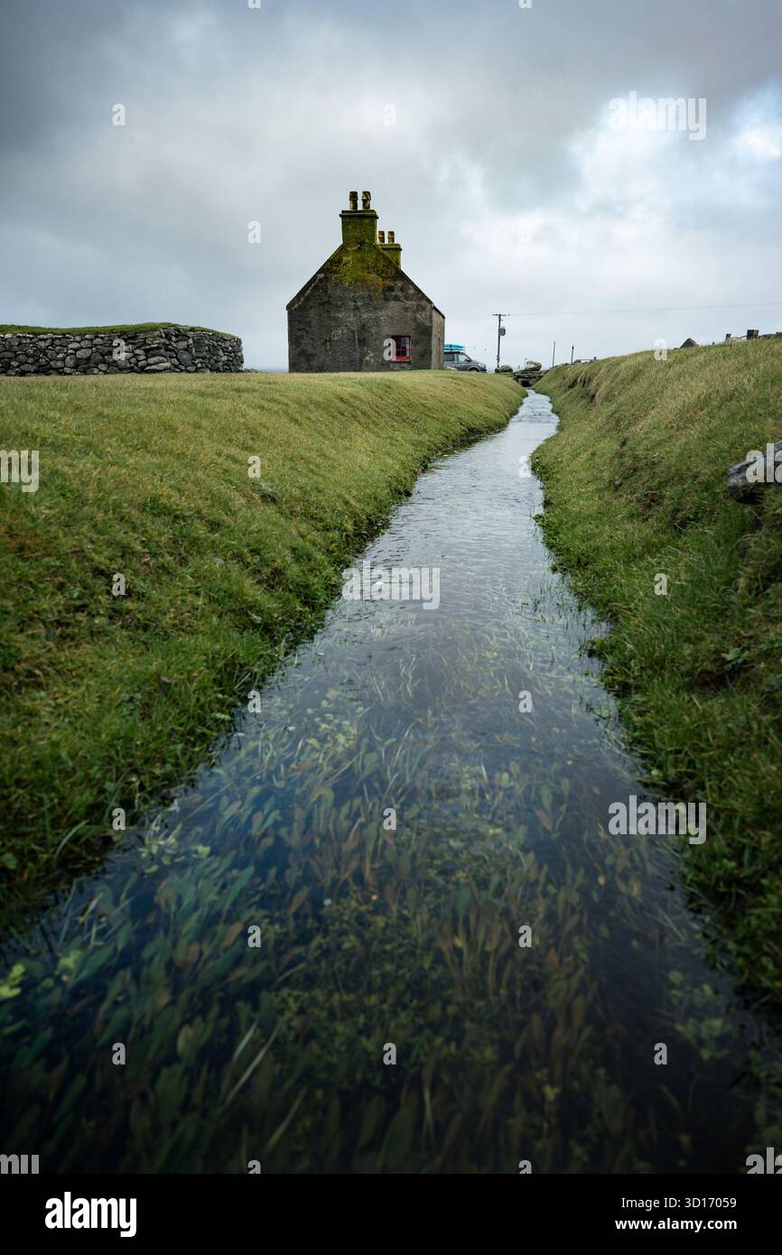 Traditional blackhouse in the Outer Hebrides, Scotland, with a water ...