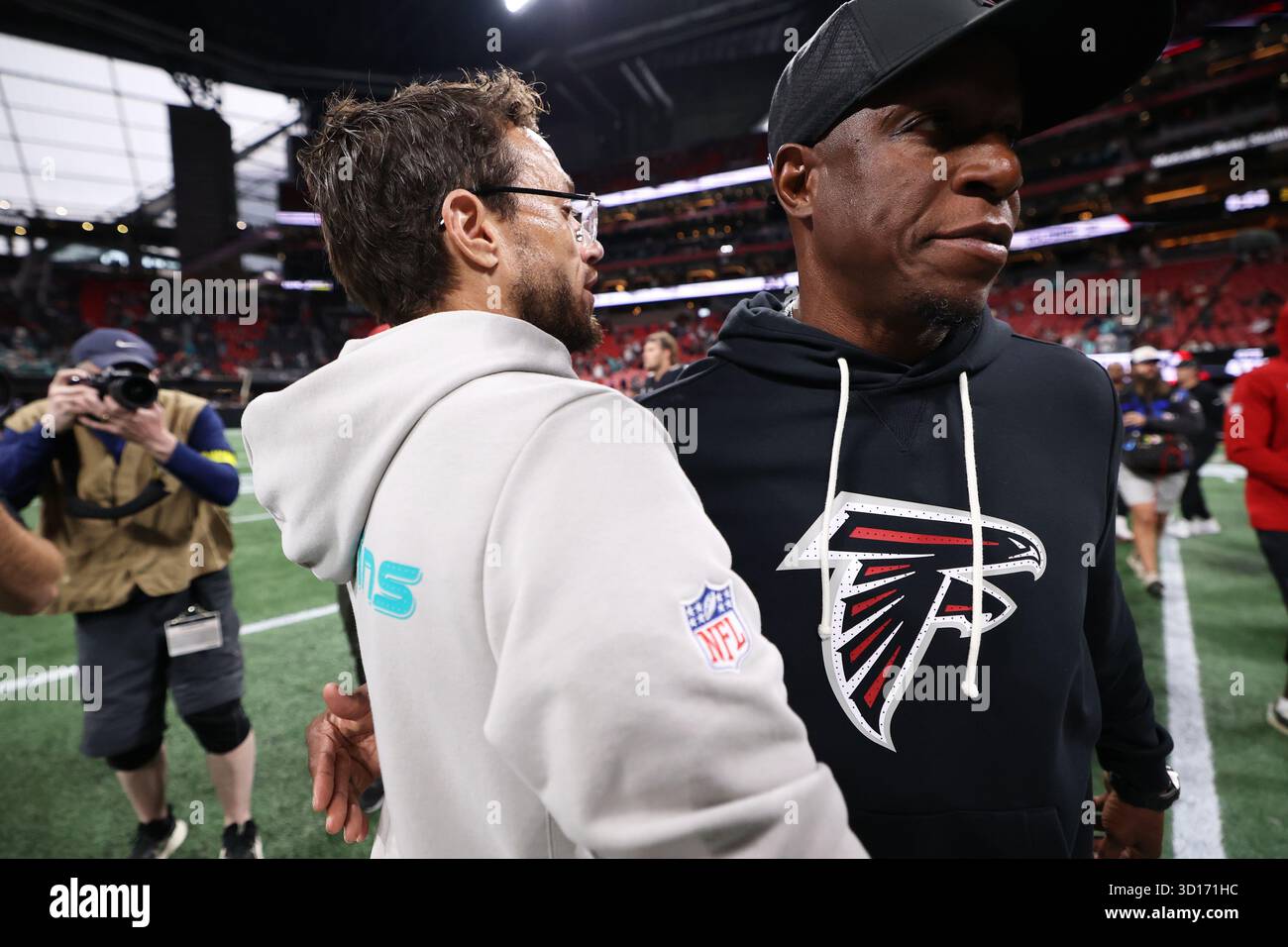 Miami Dolphins head coach Mike McDaniel, left, meets on the field with ...