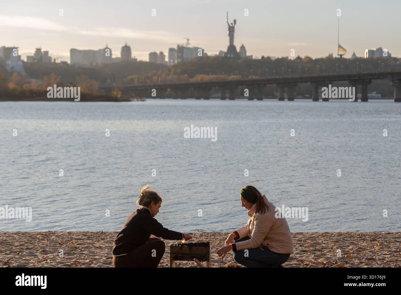 The Ukrainian Motherland Monument is seen as women light a fire on ...