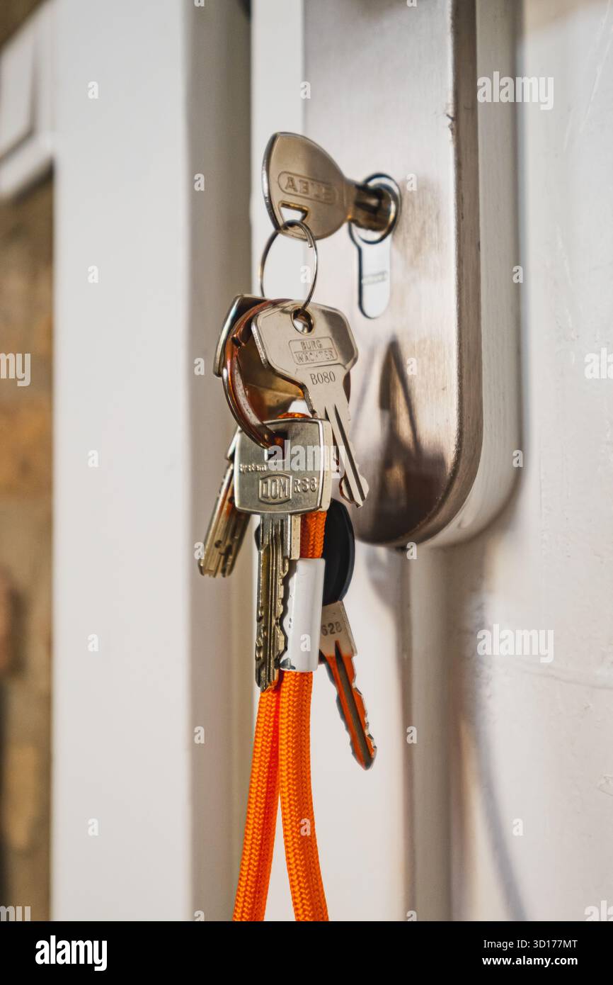 Set of house keys inserted into a door lock Stock Photo - Alamy